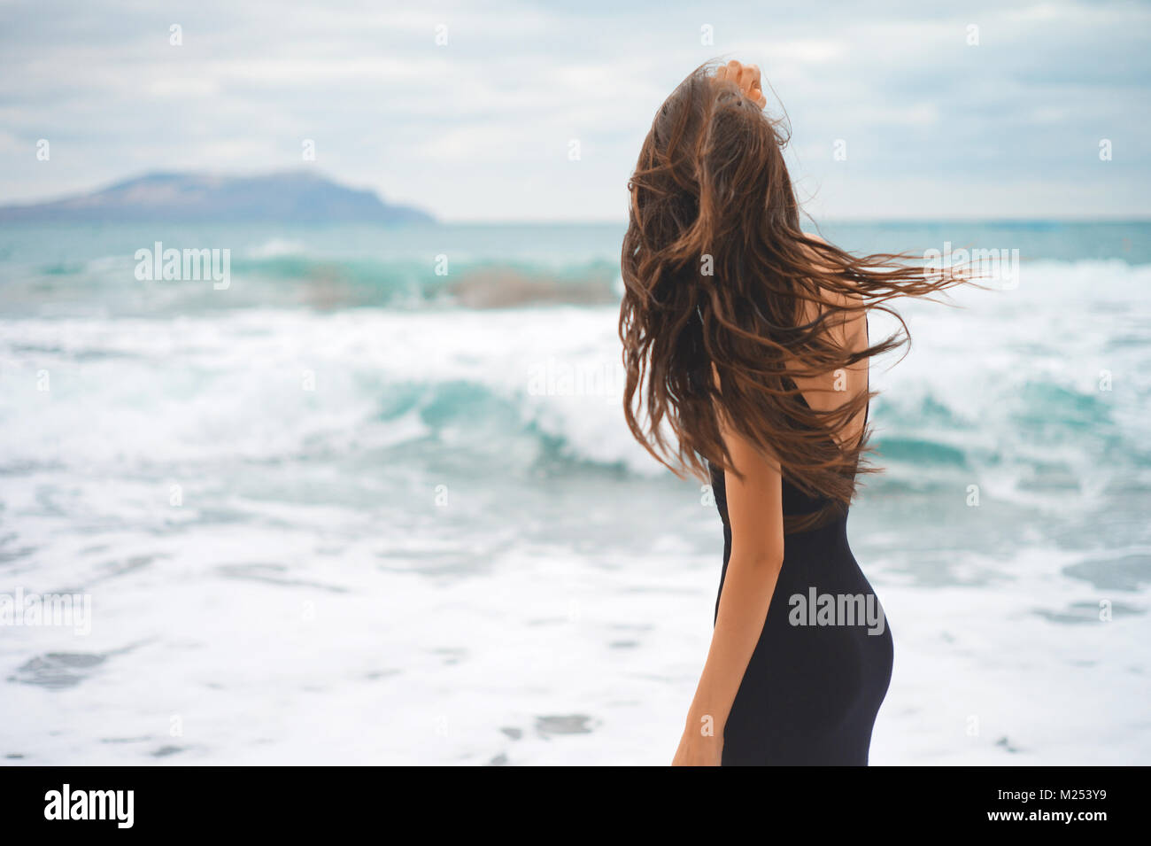 Outdoor photo of beautiful young woman walking at the sea Stock Photo ...