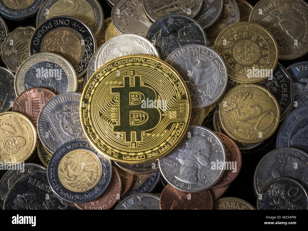 Golden bitcoin over a pile of various coins Stock Photo - Alamy