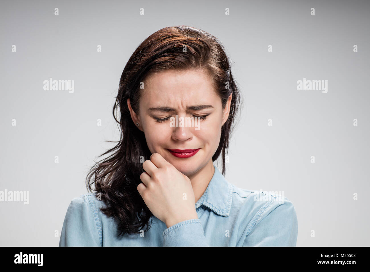 The portrait of a crying young lonely woman on gray Stock Photo - Alamy