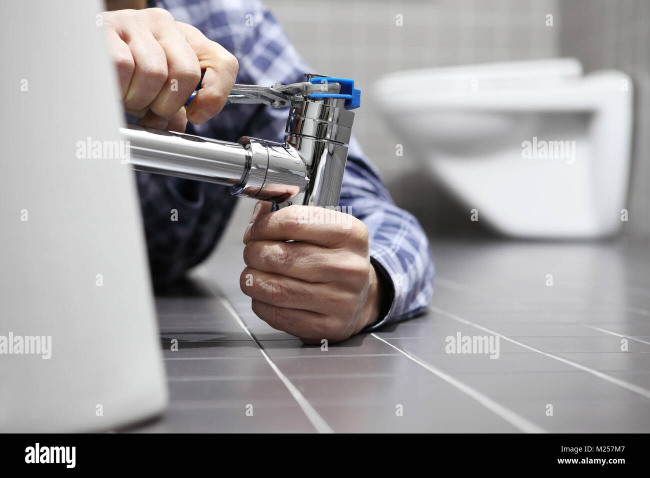hands plumber at work in a bathroom, plumbing repair service, assemble ...