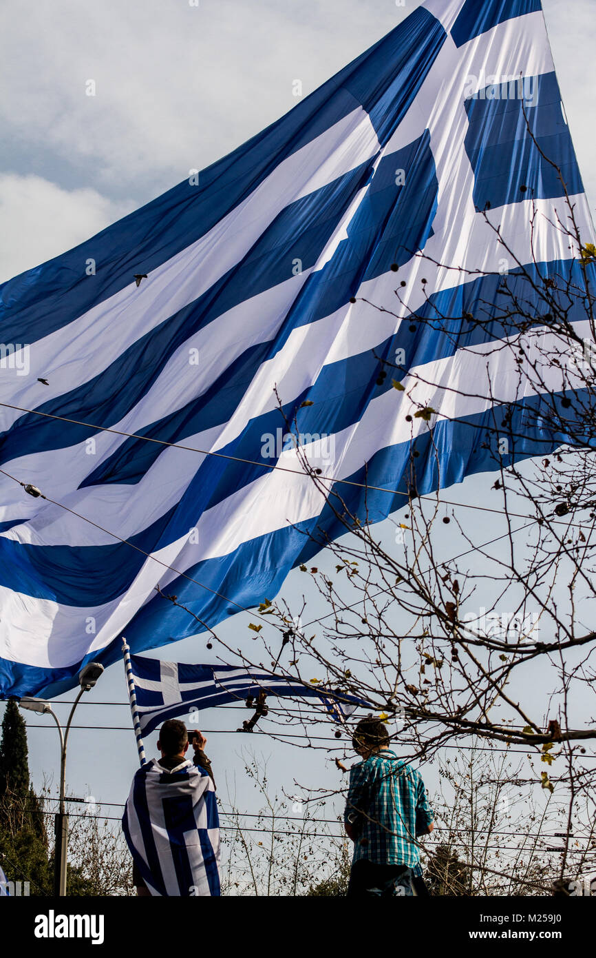 Protesters take pictures of the giant Greek flag waving above the crowd ...