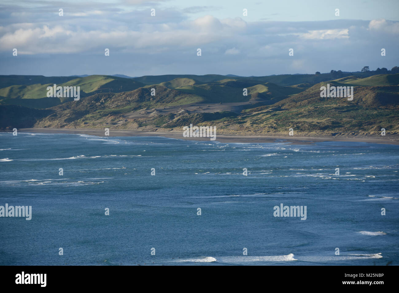 View from the hillside above Raglan surf area with waves and hills in ...