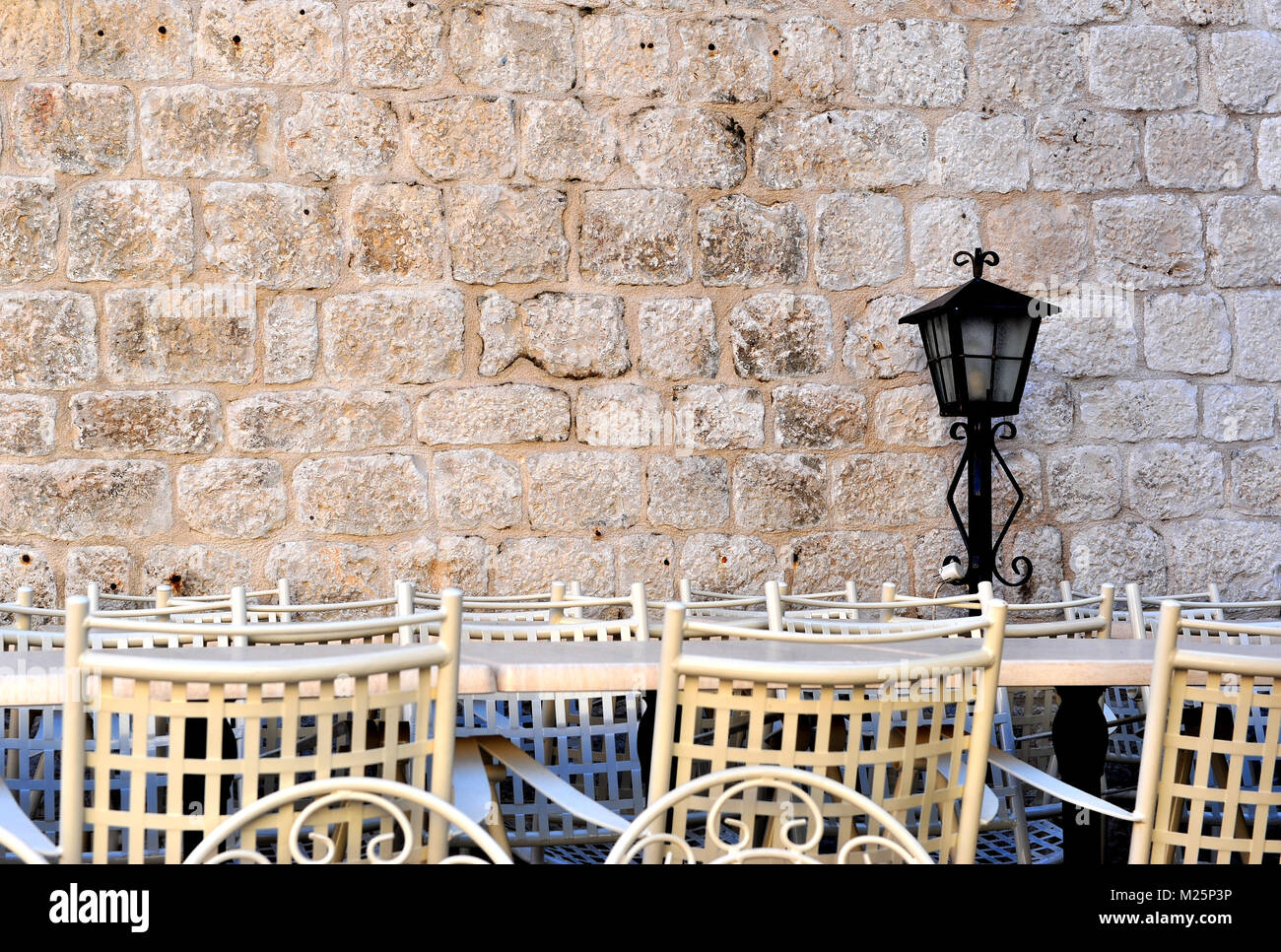 Lantern and cafe chairs at the grey wall Stock Photo - Alamy