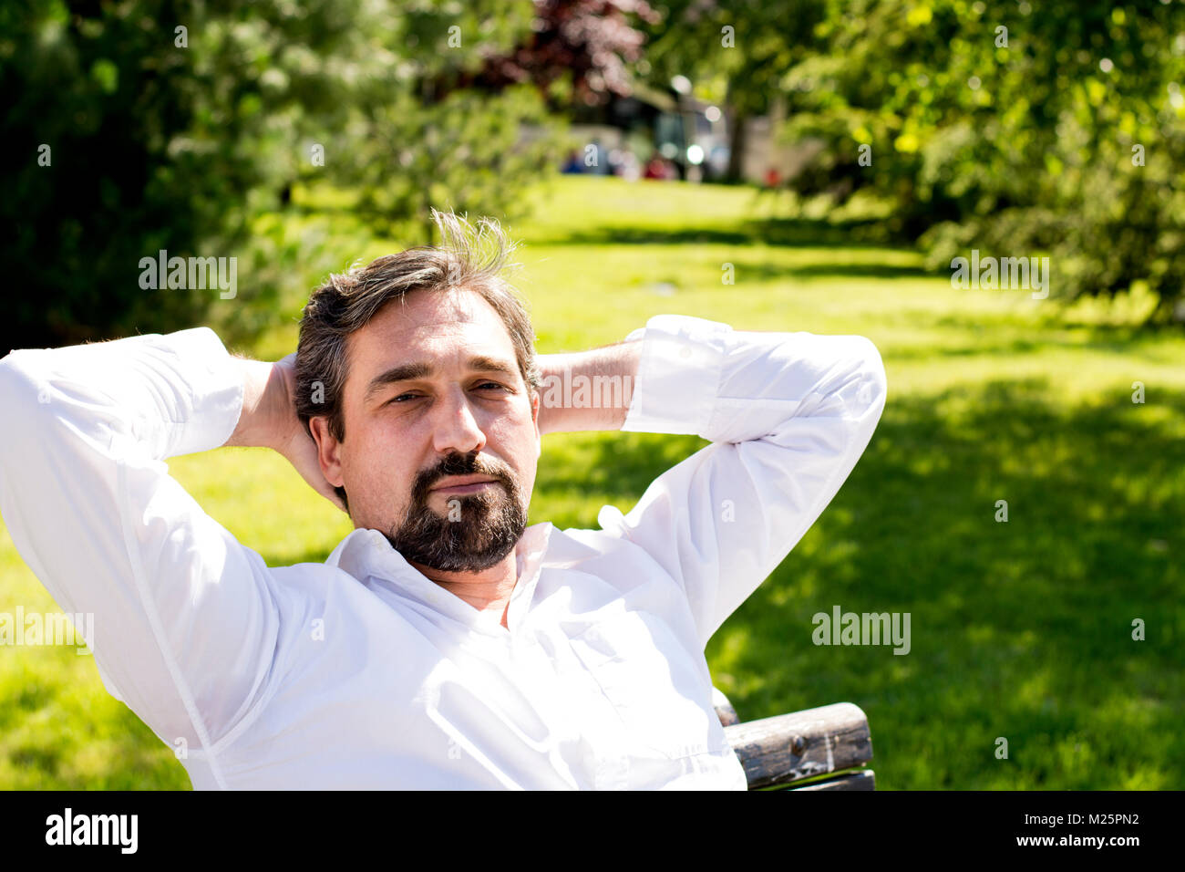 Man taking some rest after hard work in his office. Sitting on a bench ...