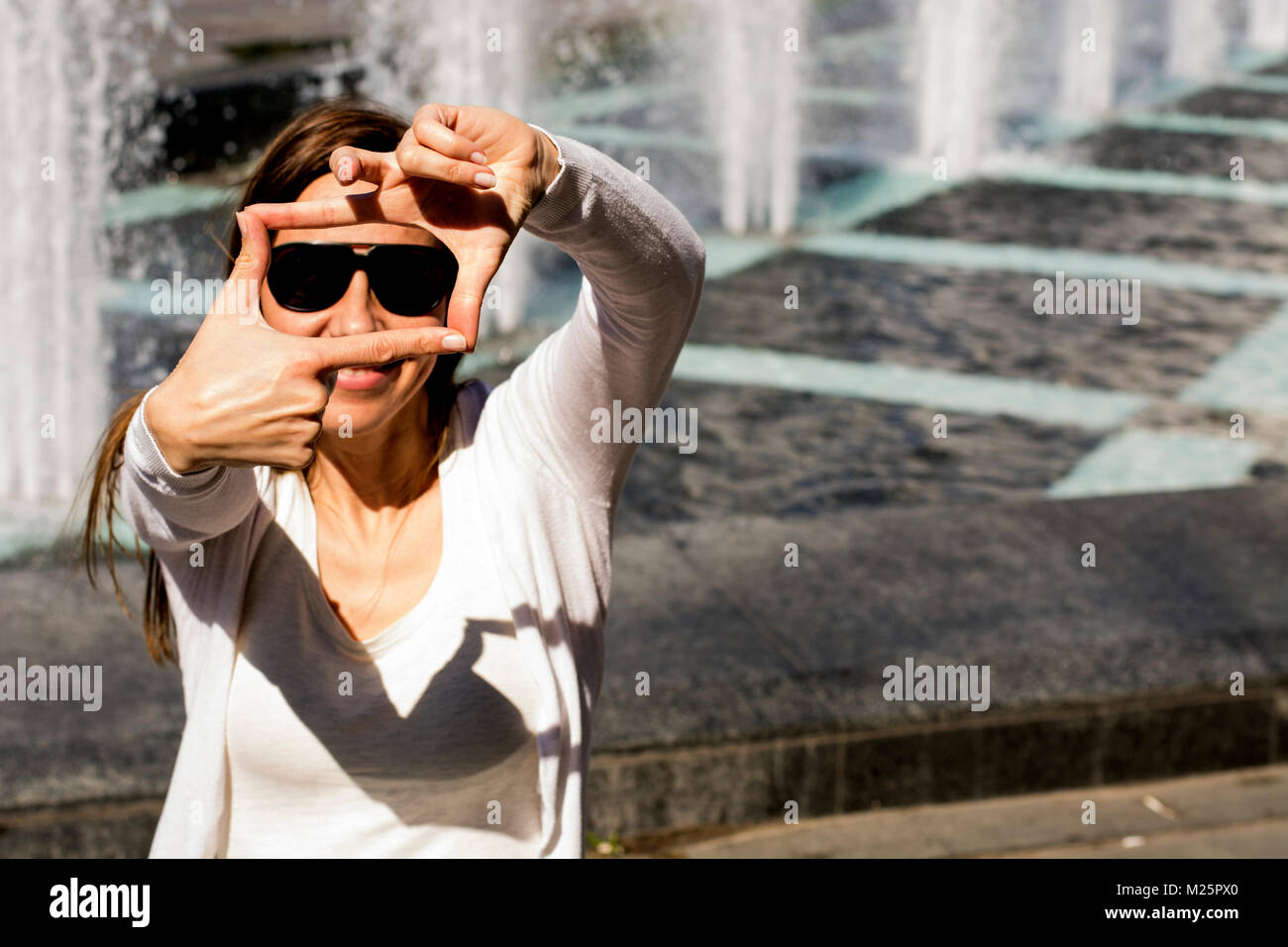 Beautiful young woman in real life, she making frame capture siting ...