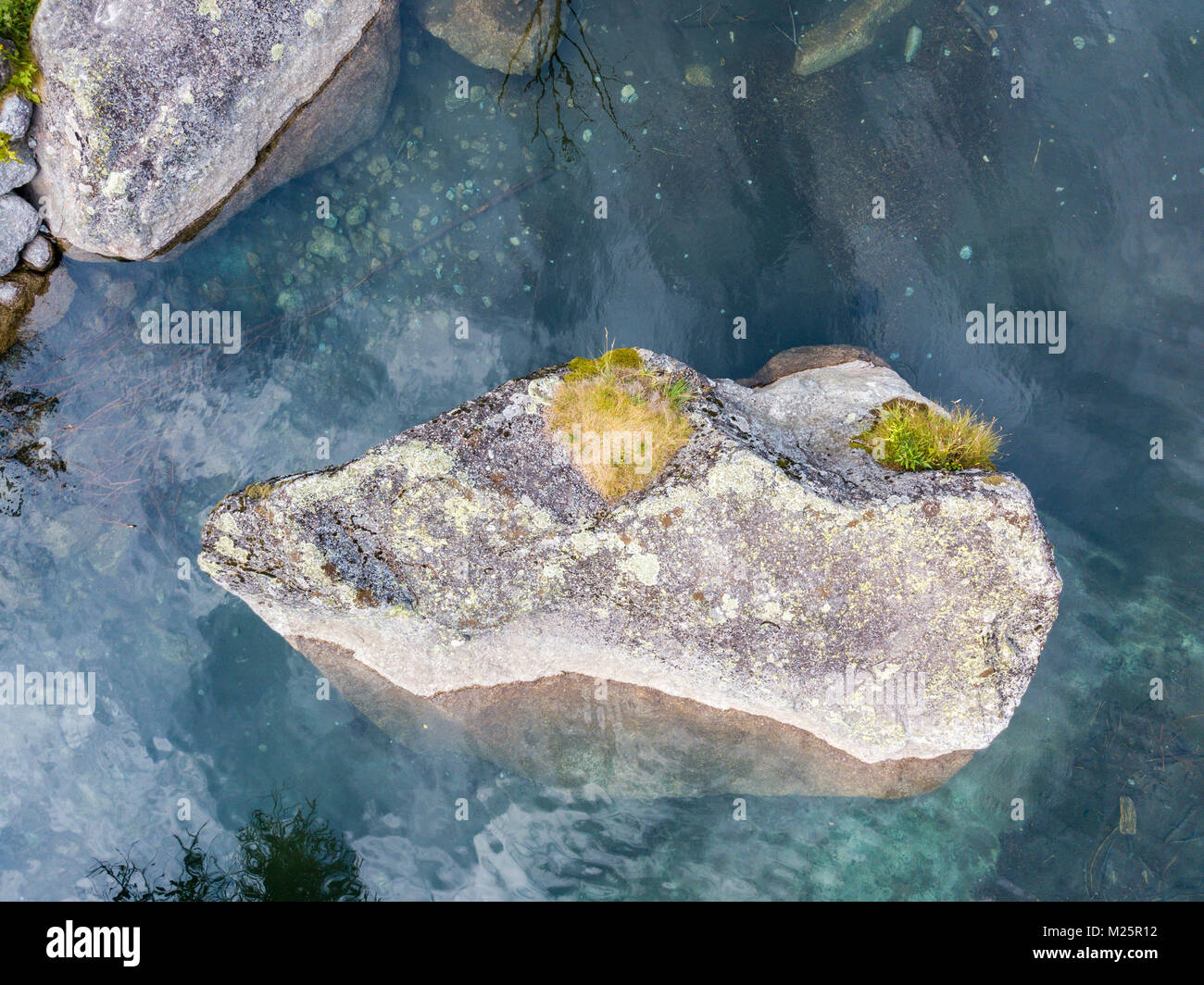 Aerial view of transparent water of a mountain lake, pebbles and rocks ...
