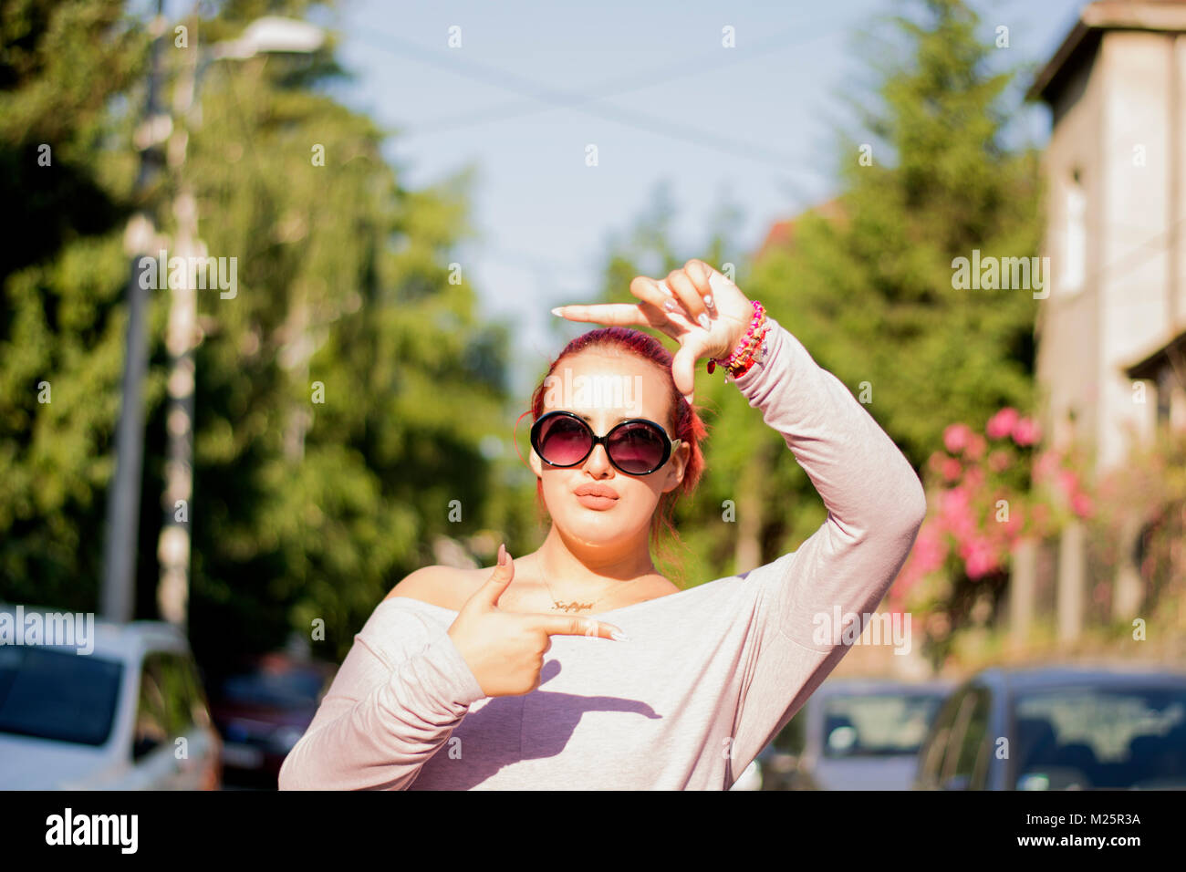 Young girl making photo frame with her hands standing at street Stock ...