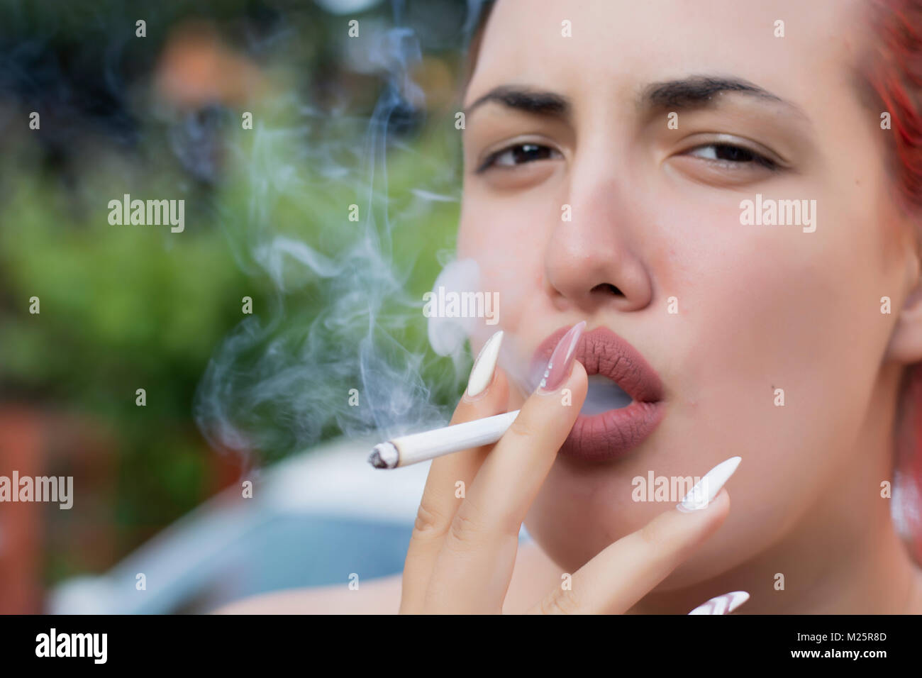 Teenage girl smoking cigarette in urban environment Stock Photo - Alamy