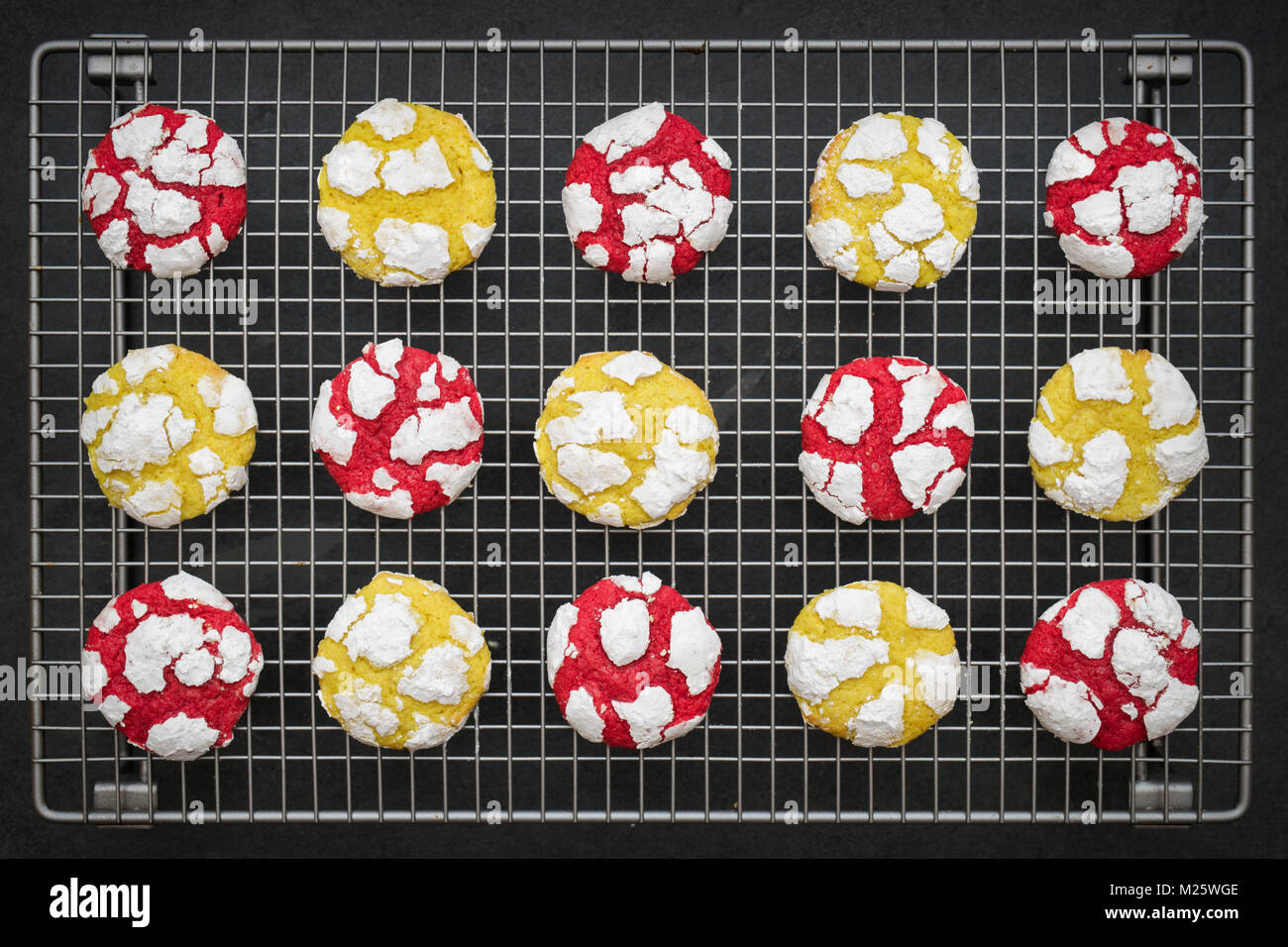 Homemade Lemon and Raspberry Crinkle Cookies on a cooling rack on slate ...