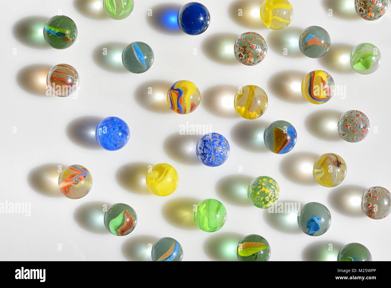 Colorfull glass marbles on white table Stock Photo - Alamy
