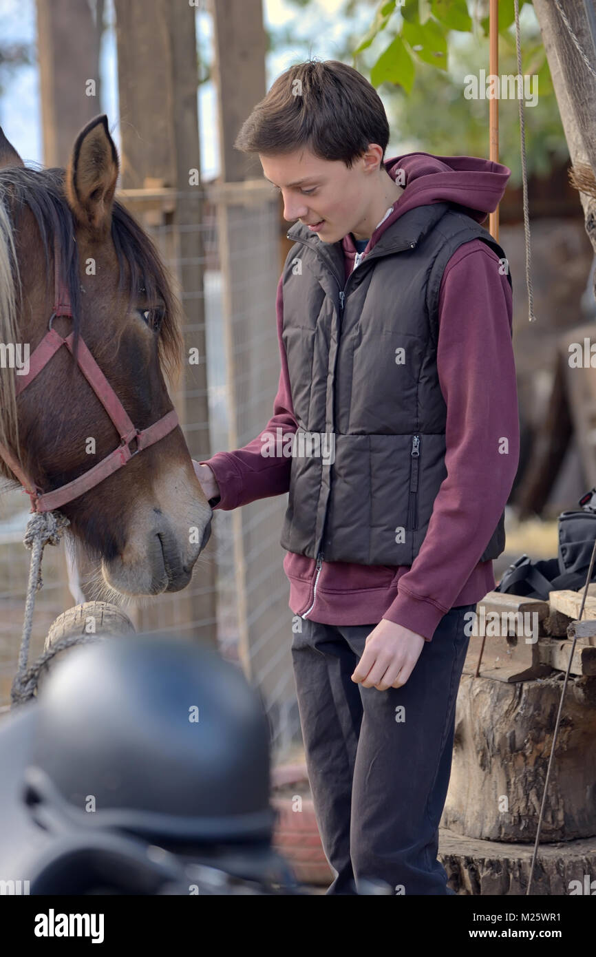 Happy teenager boy with horse at ranch Stock Photo - Alamy