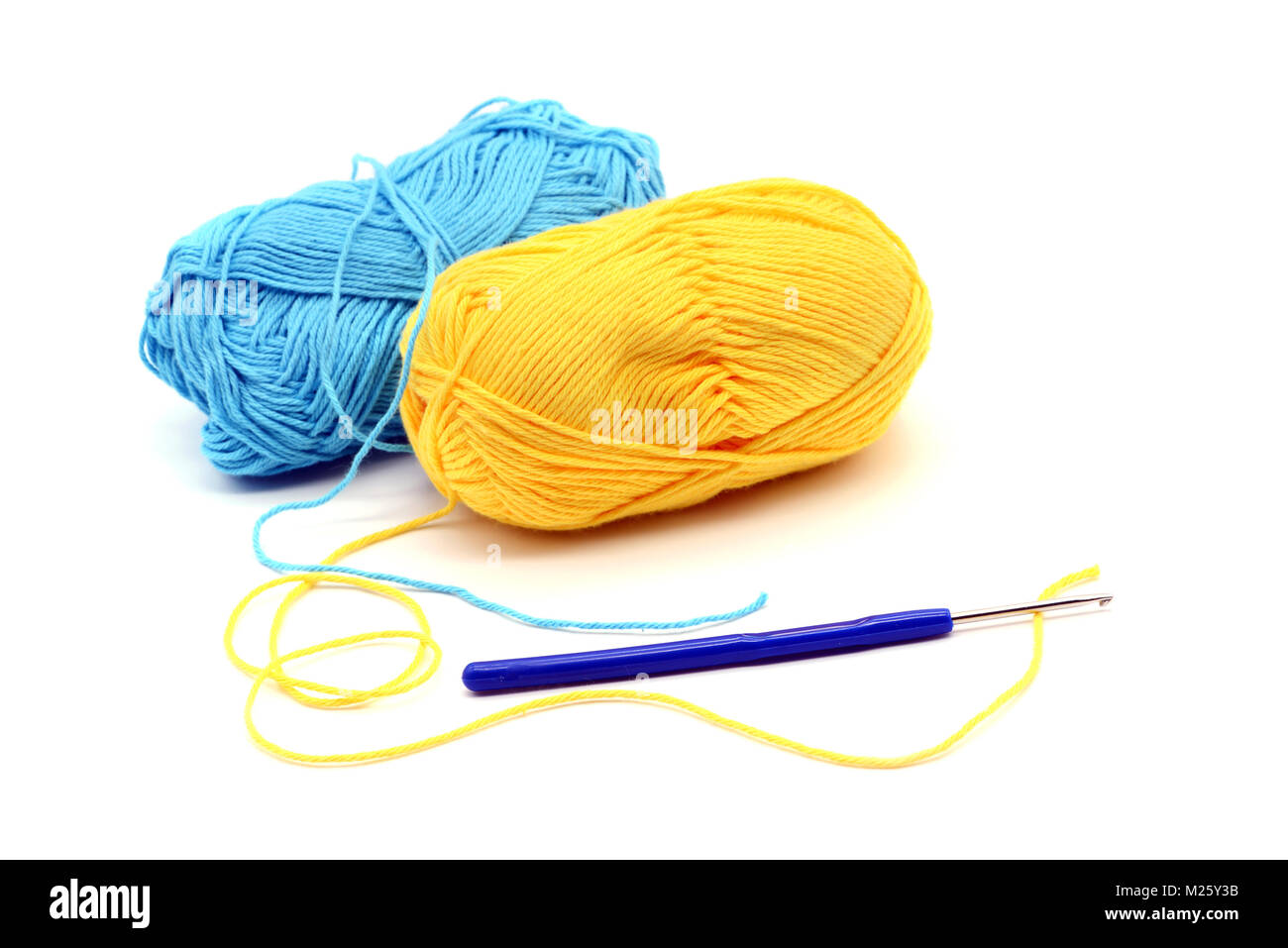 yellow and blue wool ball and crochet hook on white isolated background ...