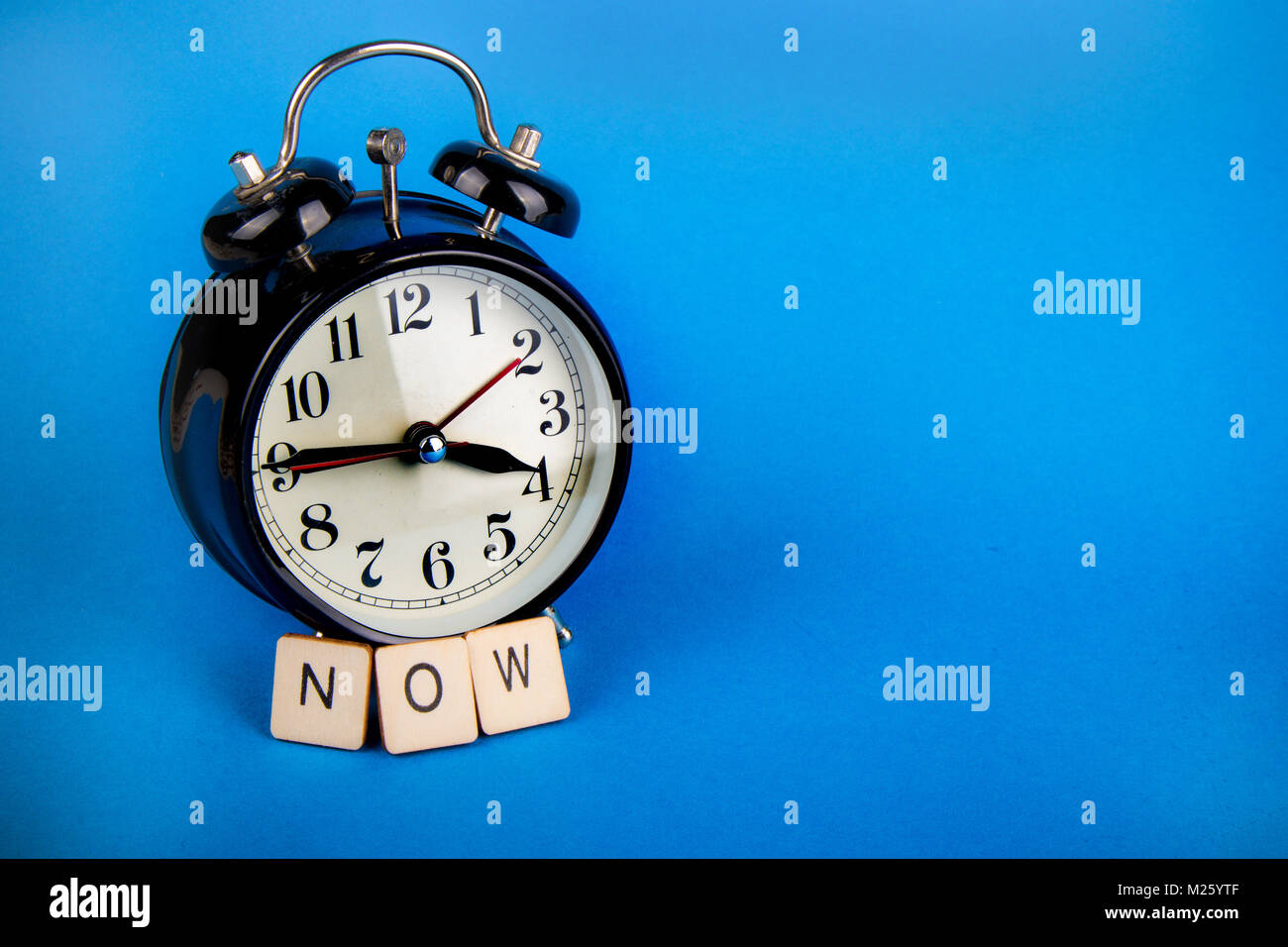 Black alarm clock with a blue background showing time with a sign ...