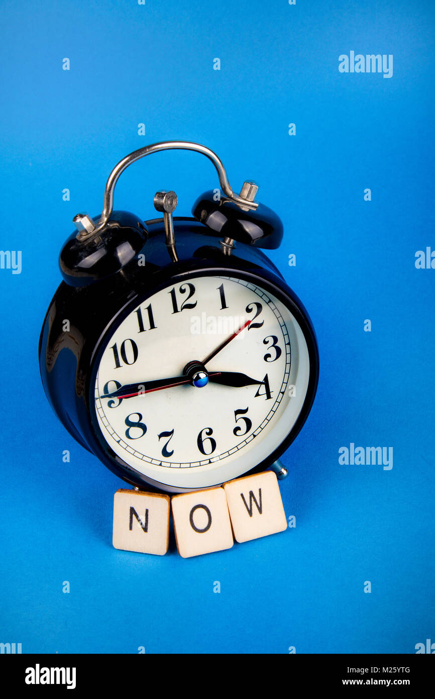 Black alarm clock with a blue background showing time with a sign ...