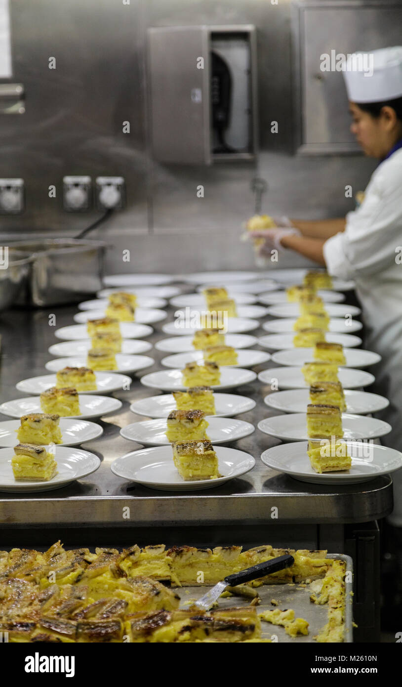 A commercial kitchen in a restaurant with cooks, food preparers and ...