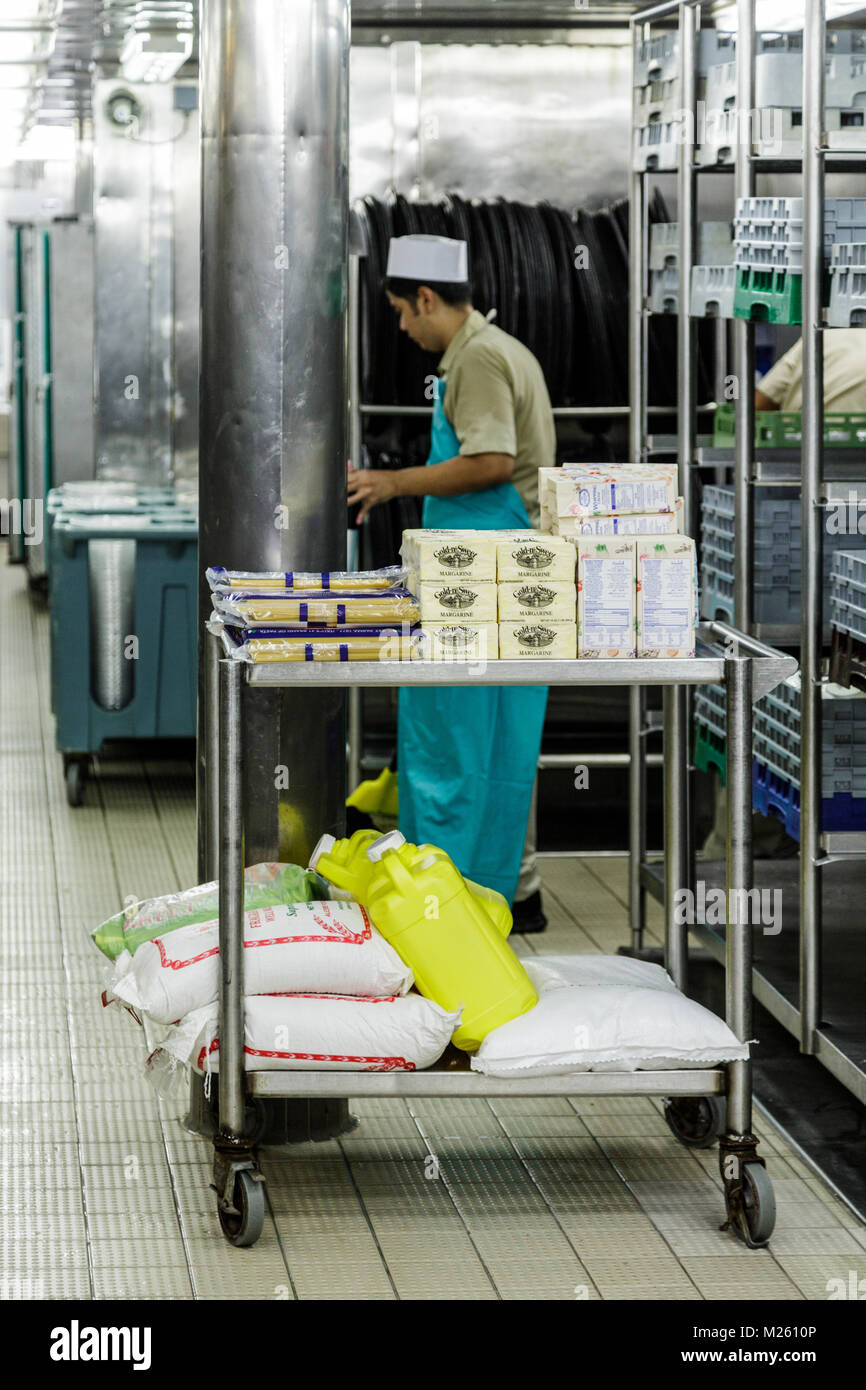 A commercial kitchen in a restaurant with cooks, food preparers and ...