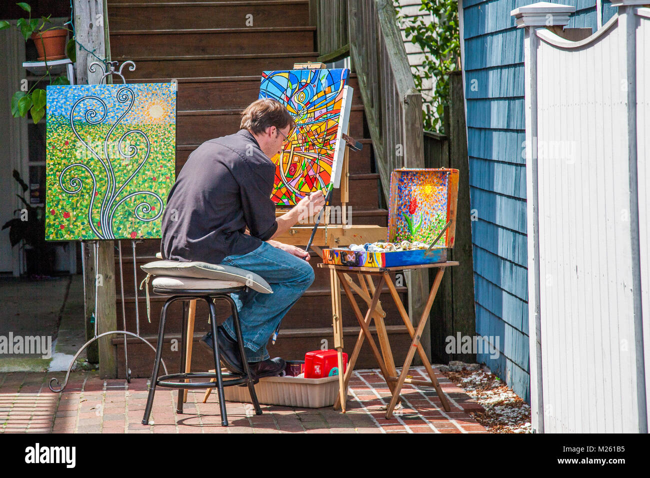 An artist painting on a street in Rockport near his studio Stock Photo ...