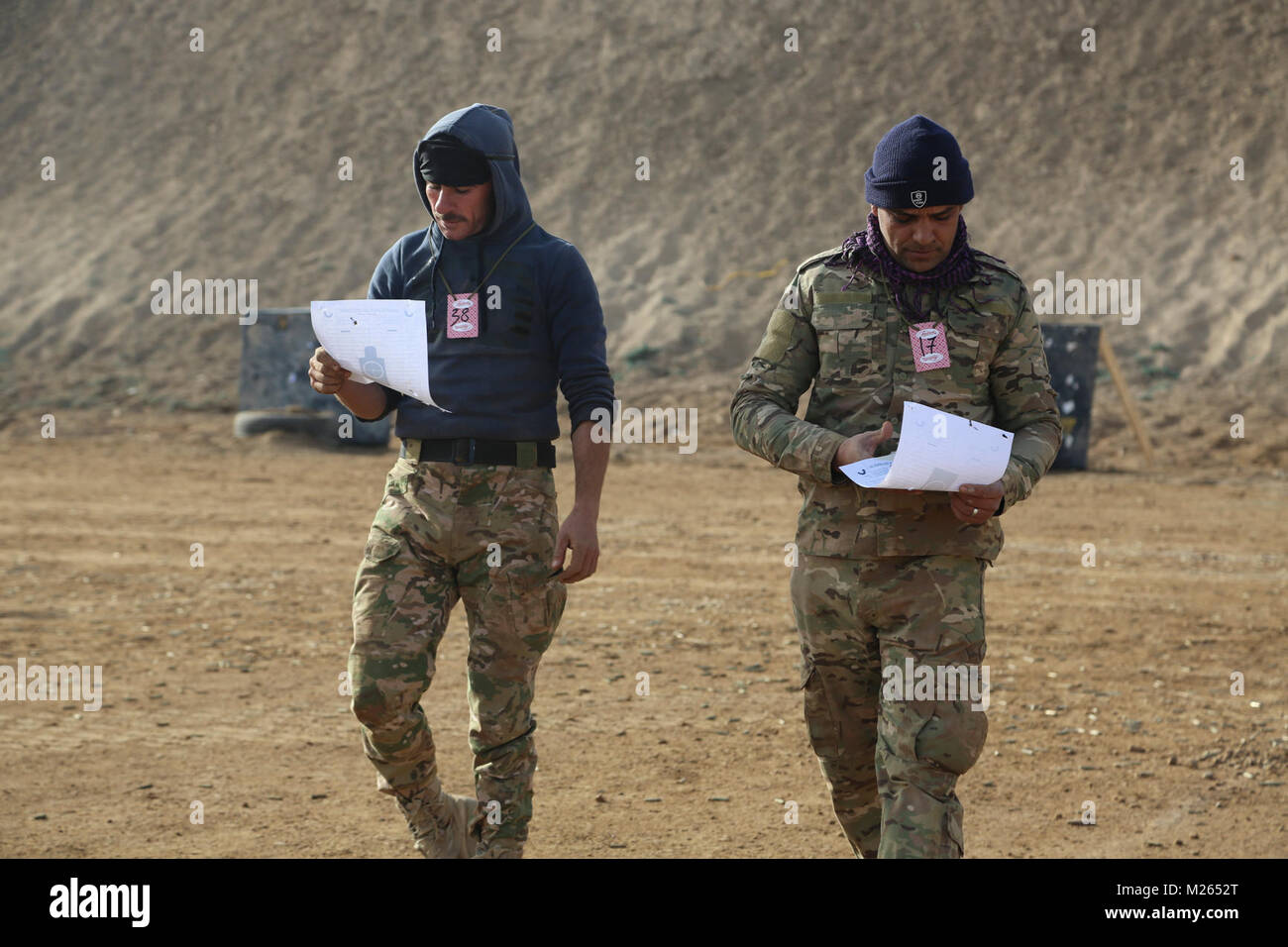 Two Iraqi soldier’s look at their target to see how well they fired ...