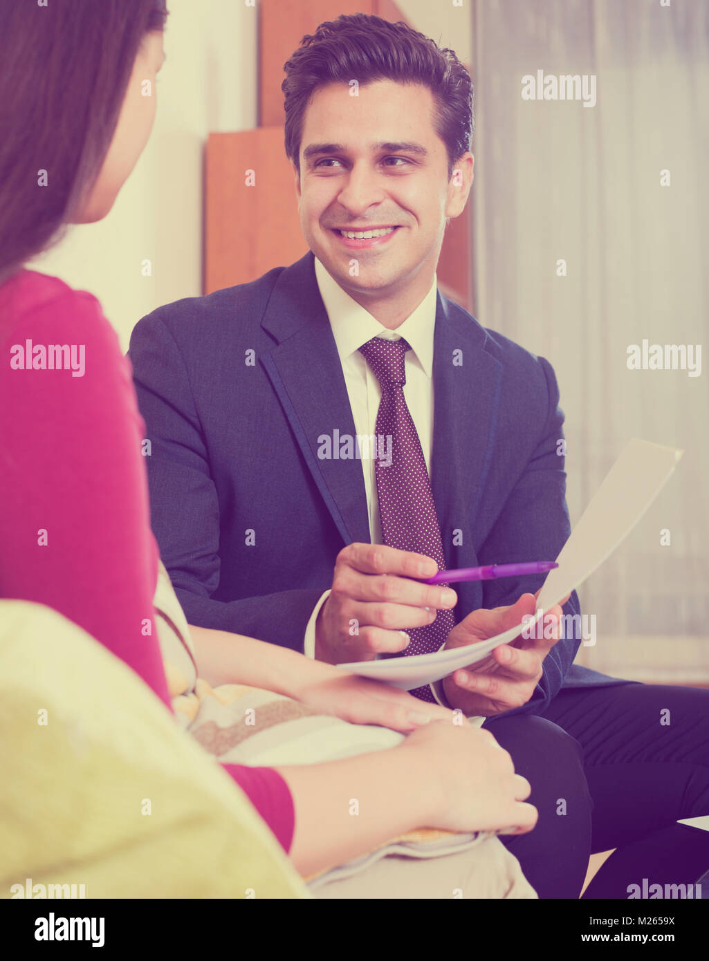 Positive agent explaining customer mortgage agreement at home Stock ...