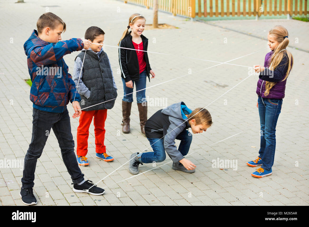Children games. Smiling cheerful positive girl goes through the tangled ...