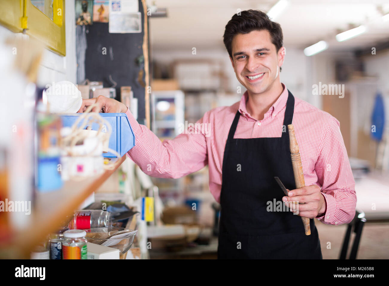 Portrait of craftsman with tool in hand near shelves in carpentry Stock ...