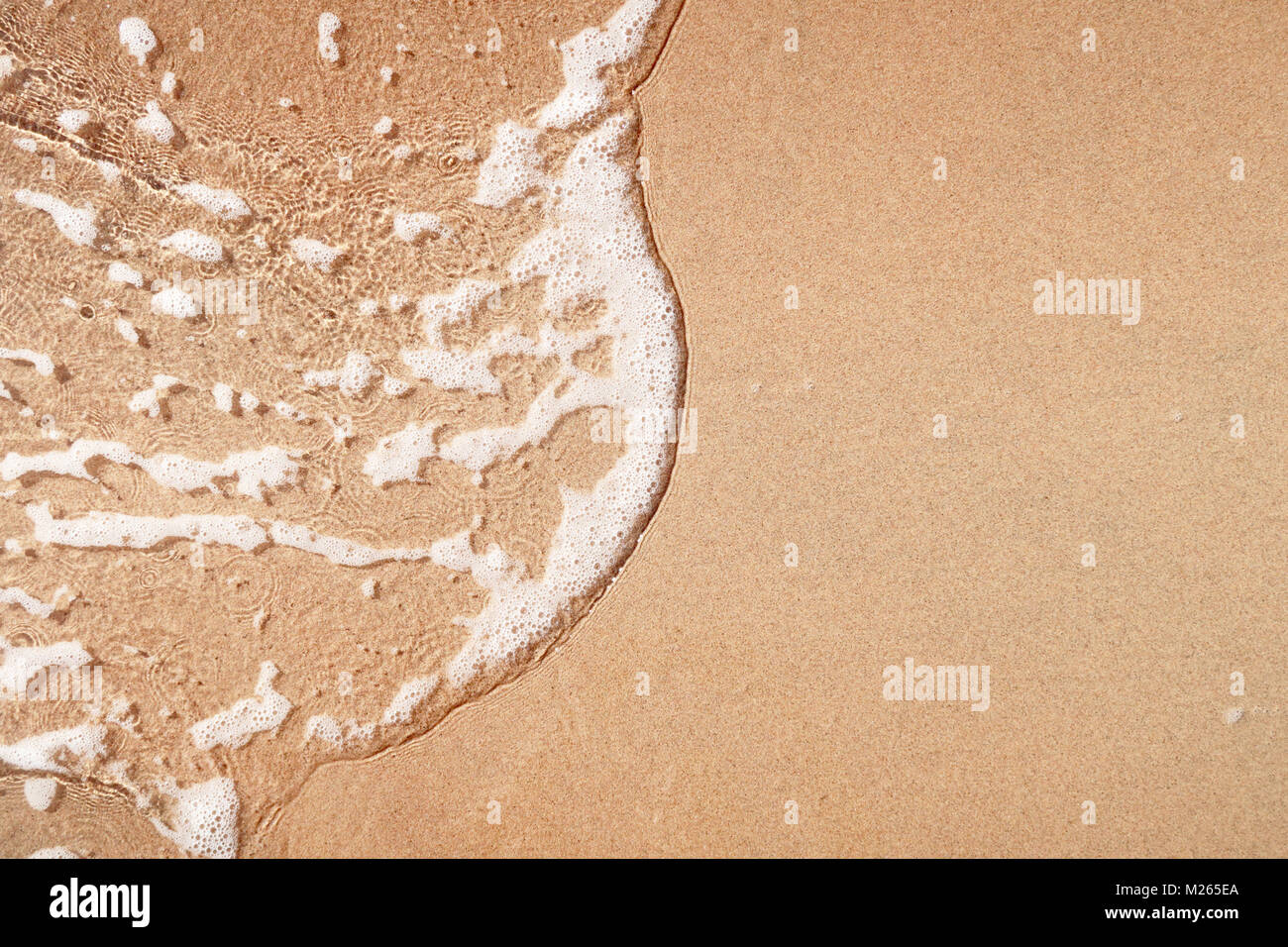 Transparent soft wave on sandy beach Stock Photo - Alamy