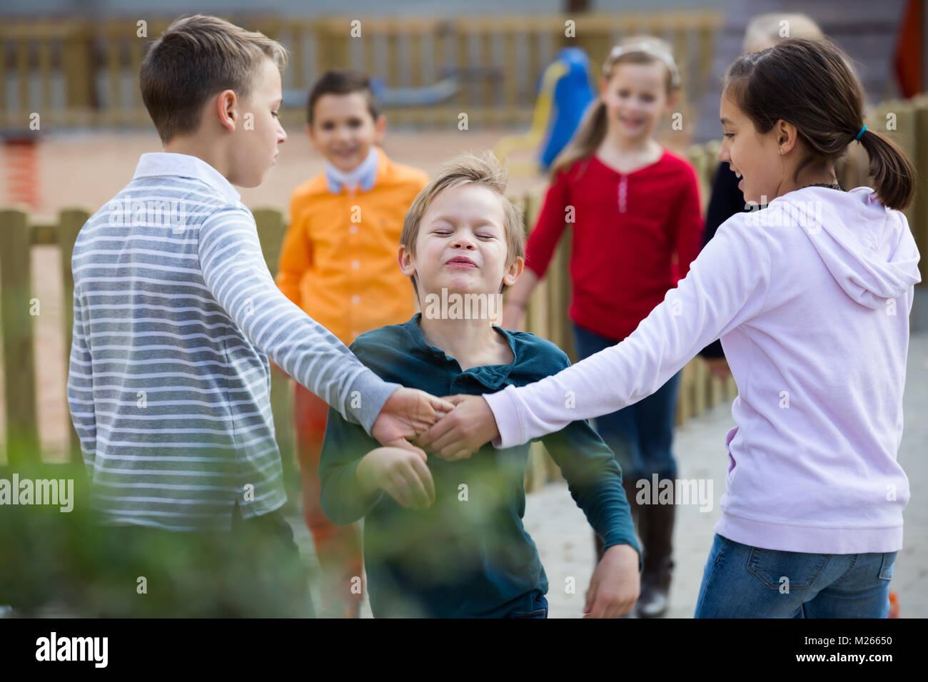 Group of laughing children playing red rover outdoors Stock Photo - Alamy