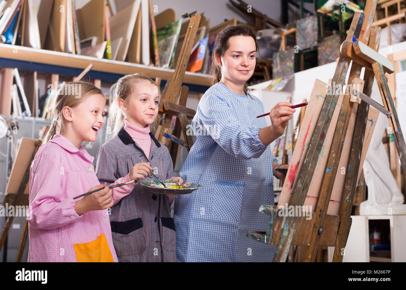 Smiling woman teacher giving workshop session during painting class at ...