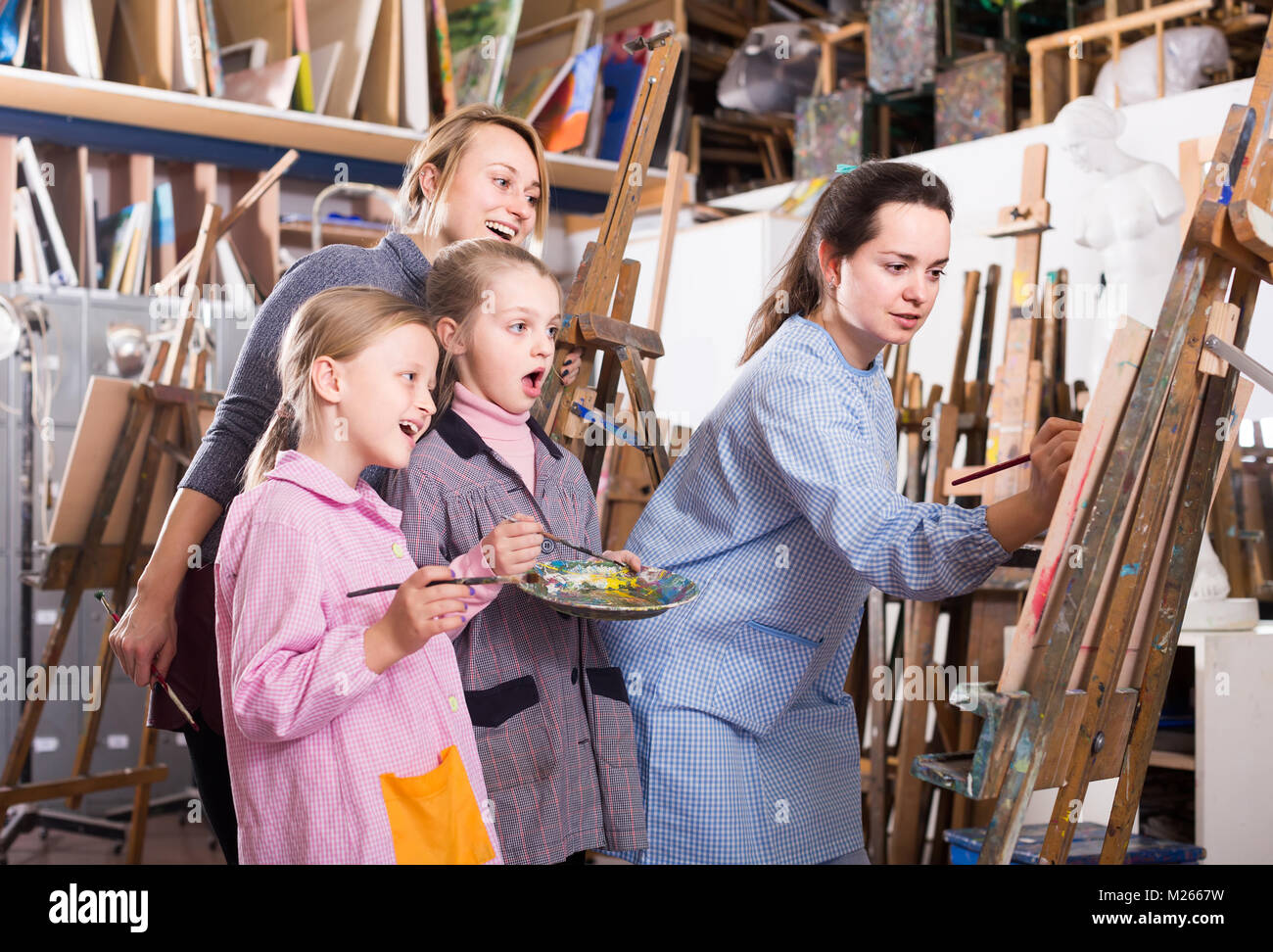 skillful young woman teacher showing her skills during painting class ...