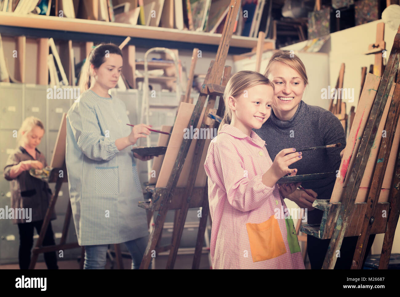 Young female pupils practicing their skills during painting class at ...