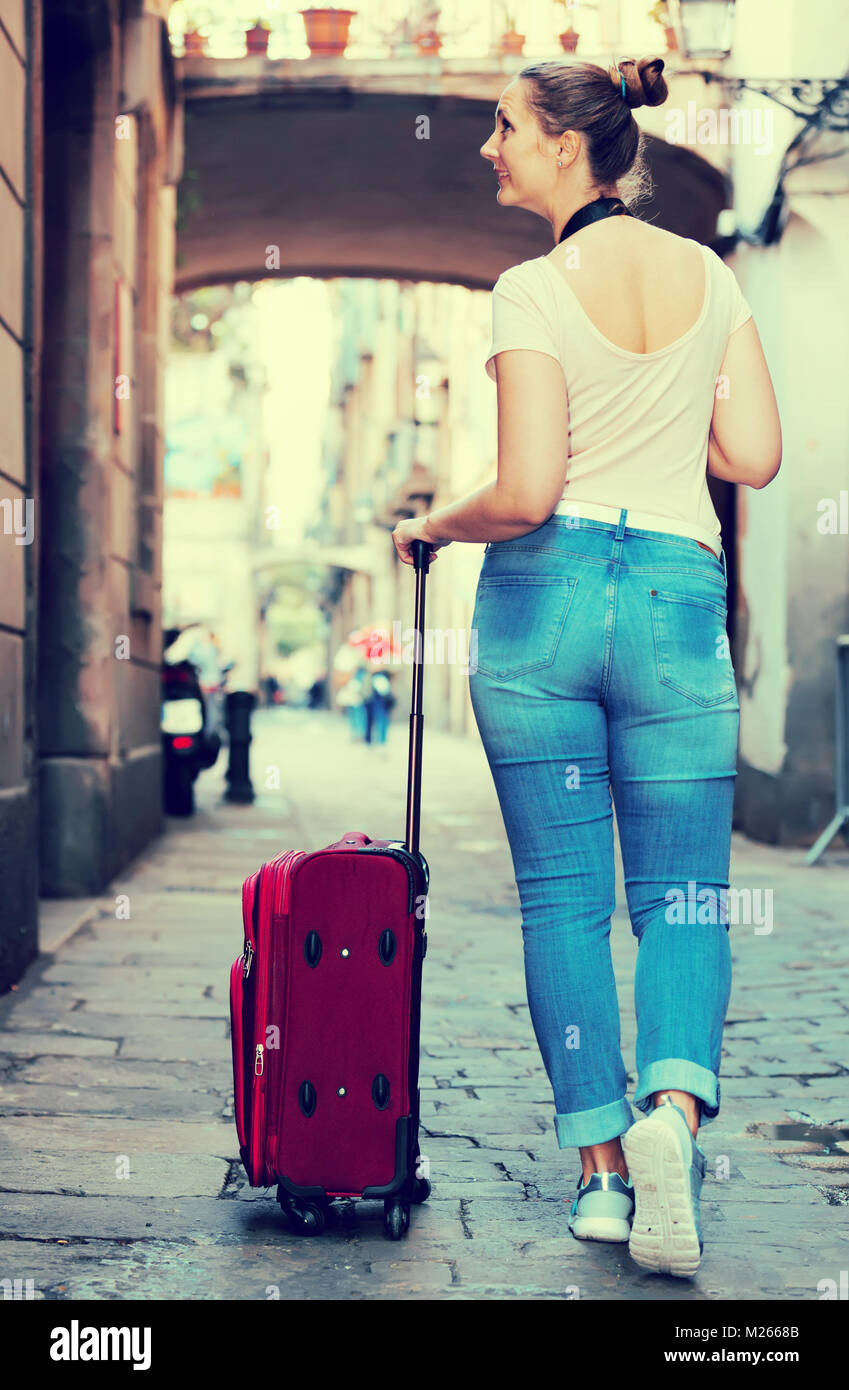 tourist woman going a walk in the town with the travel bag Stock Photo ...
