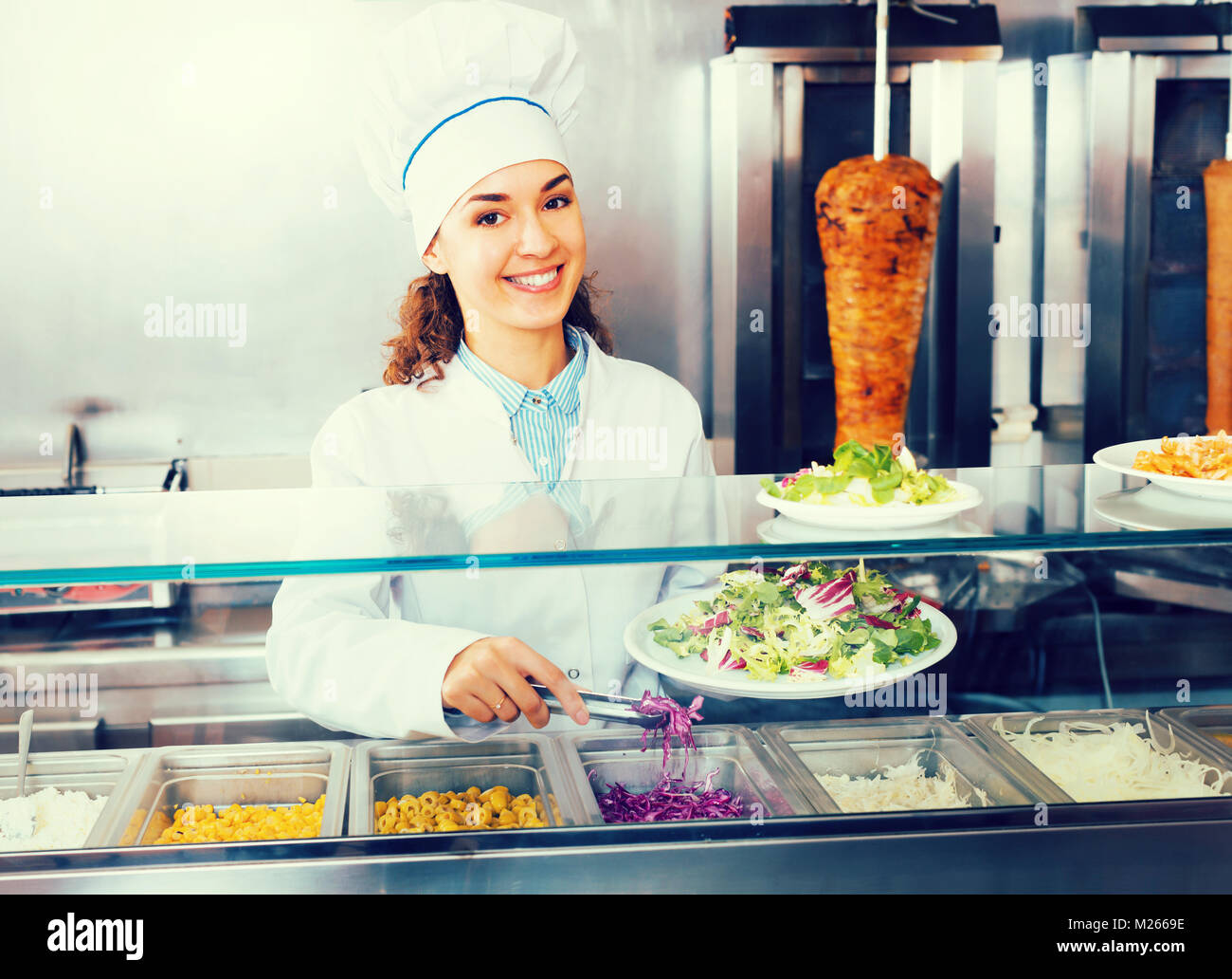 Brunette girl with kebab and vegetables at bistro Stock Photo - Alamy