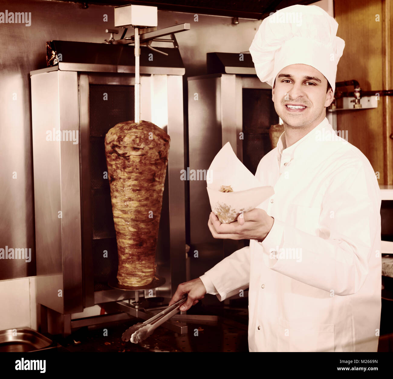 Indian cook offering kebab at counter and smiling Stock Photo - Alamy