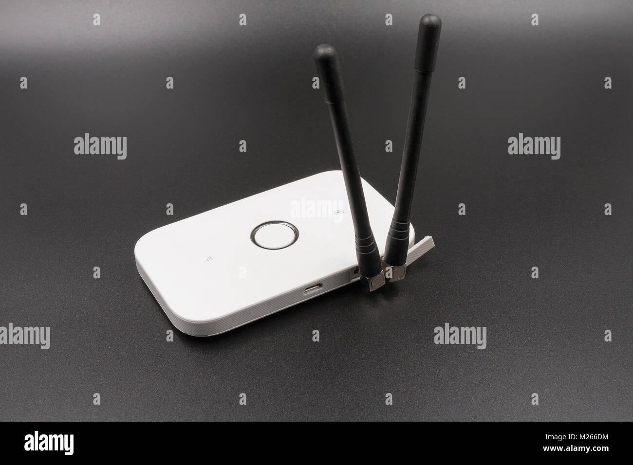 Wi-Fi portable router with connected external antennas. On a black ...