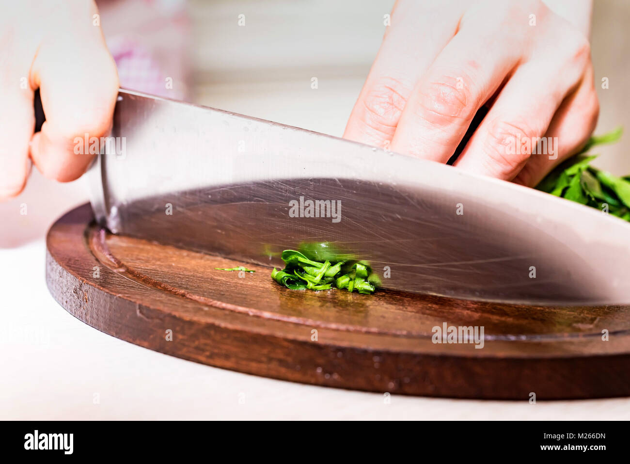 Female hands chopping herbs on wooden board Stock Photo - Alamy