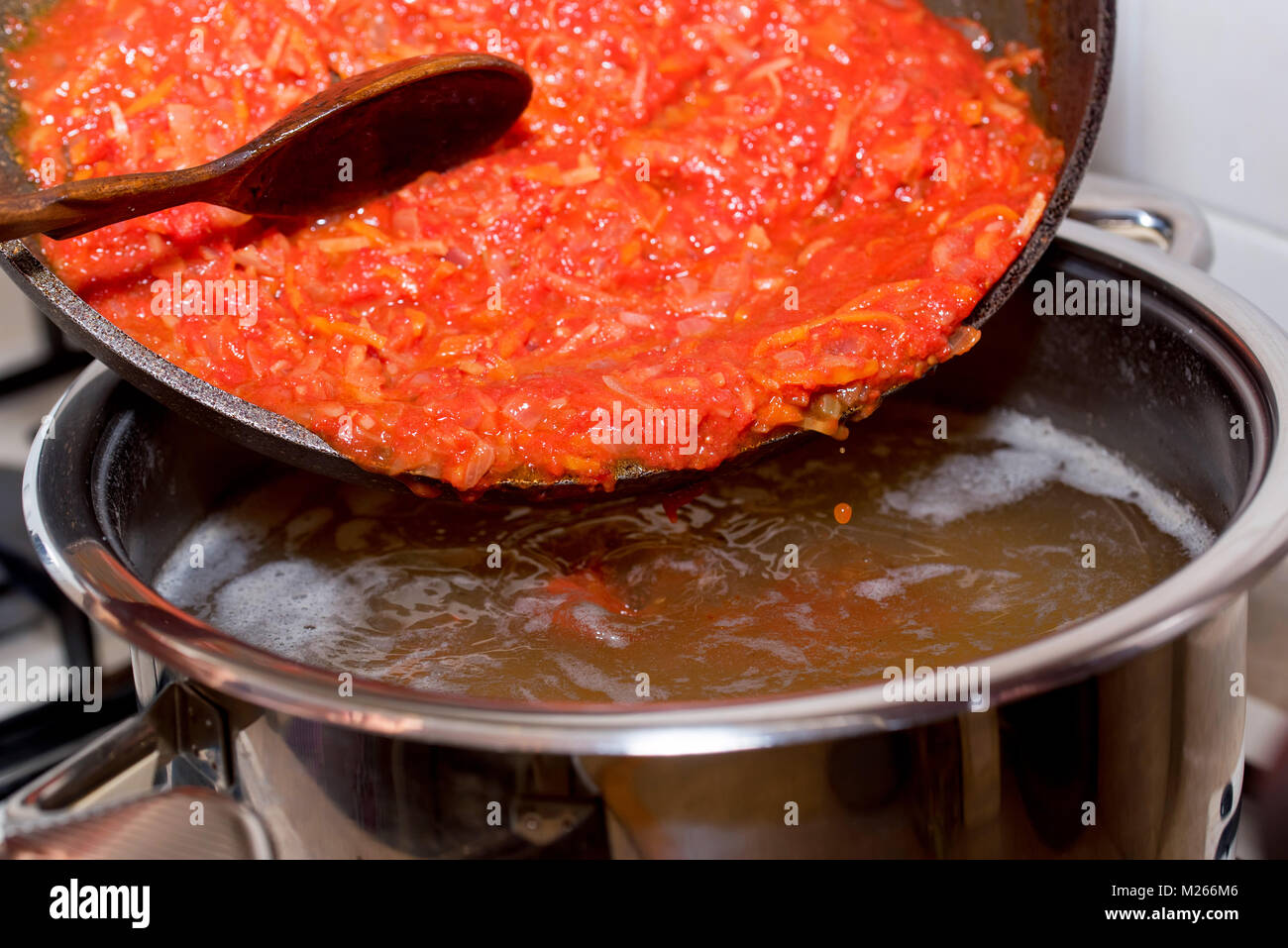 Adding roasted vegetables to borscht Stock Photo - Alamy
