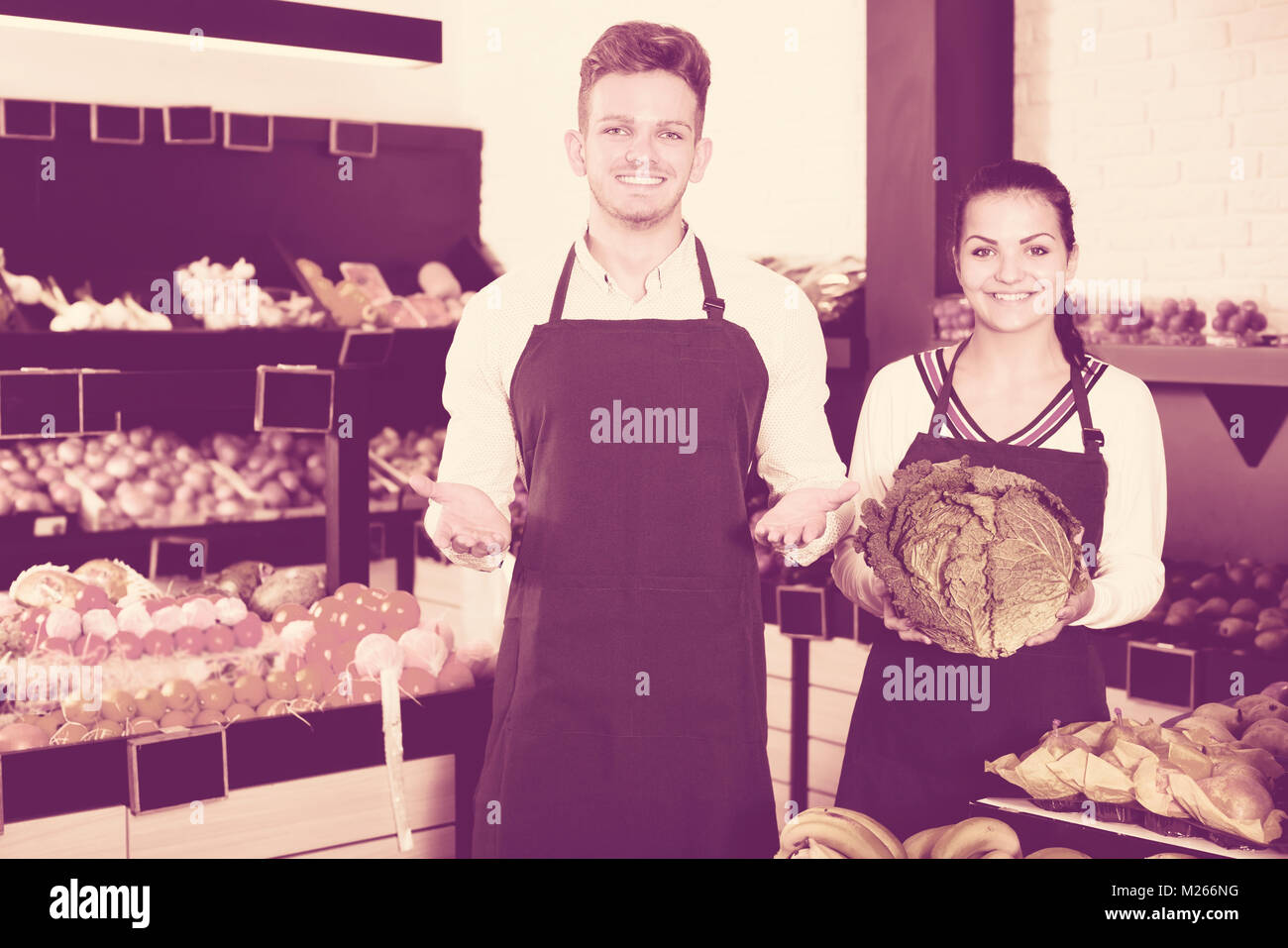 Smiling Shopping Assistants Demonstrating Assortment Of Grocery Shop