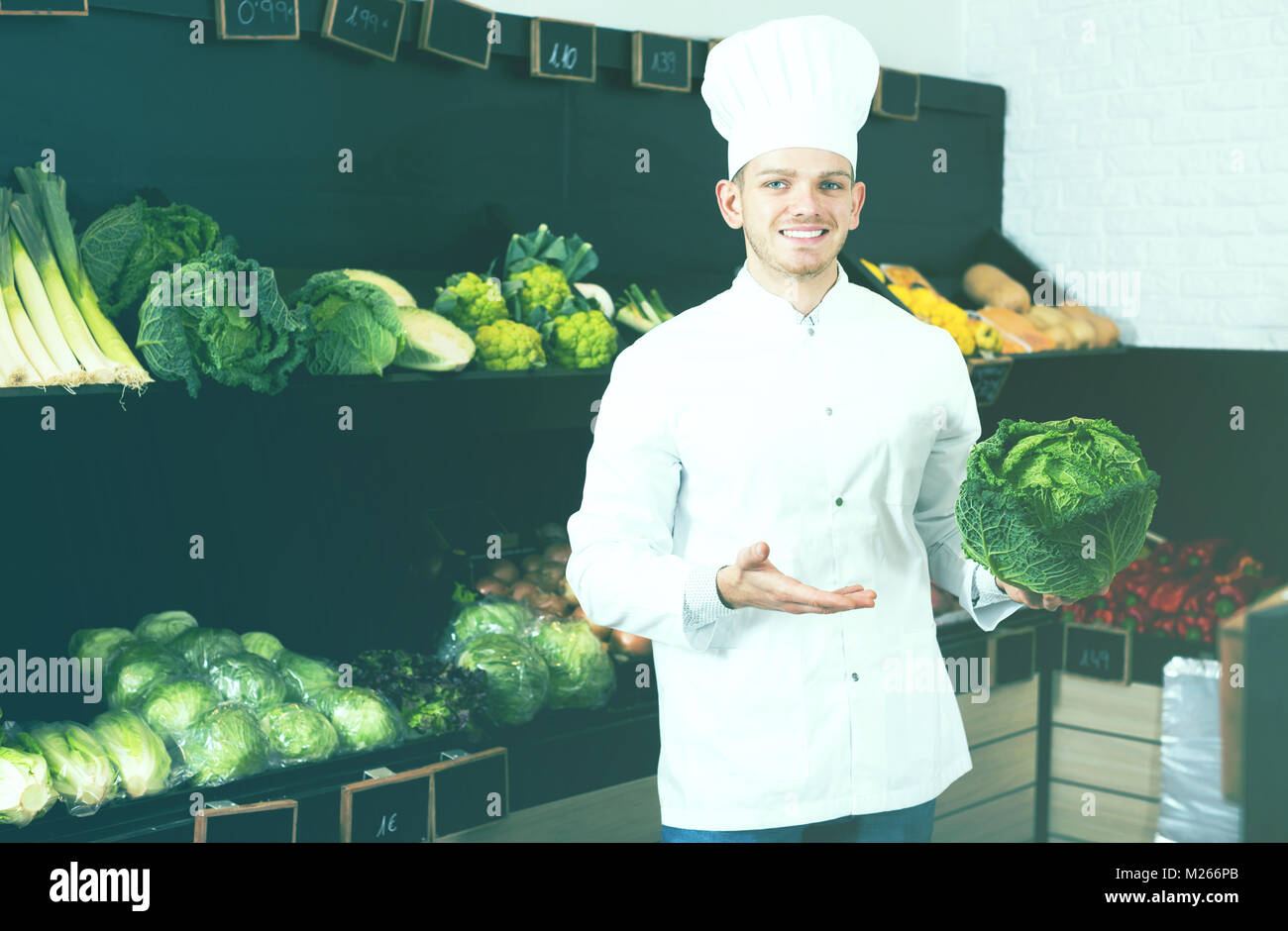 Young man cook deciding on best vegetables in grocery shop Stock Photo ...