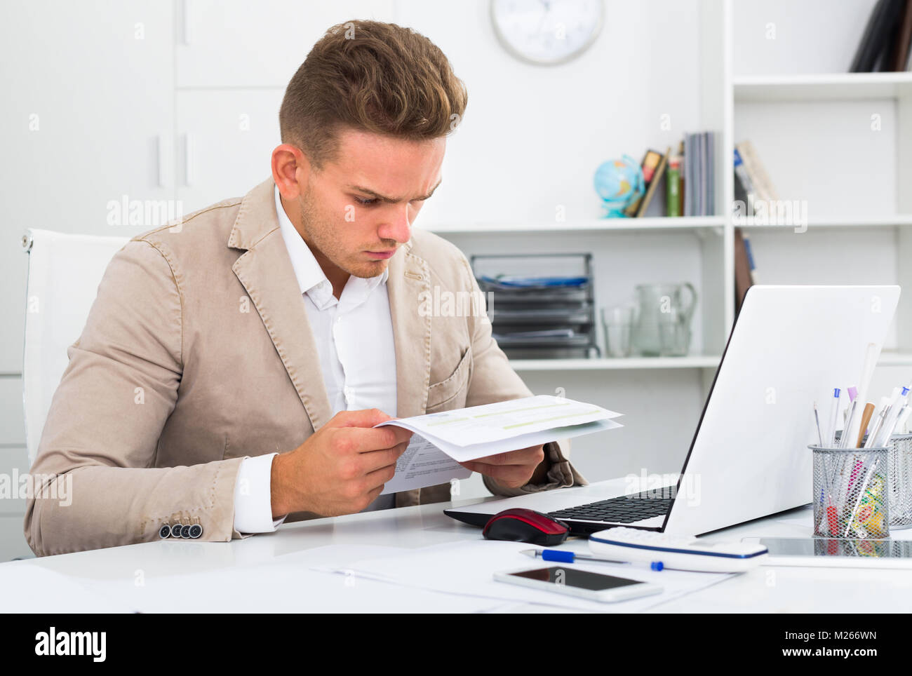 tired male admin in crisis doing paperwork at office Stock Photo - Alamy