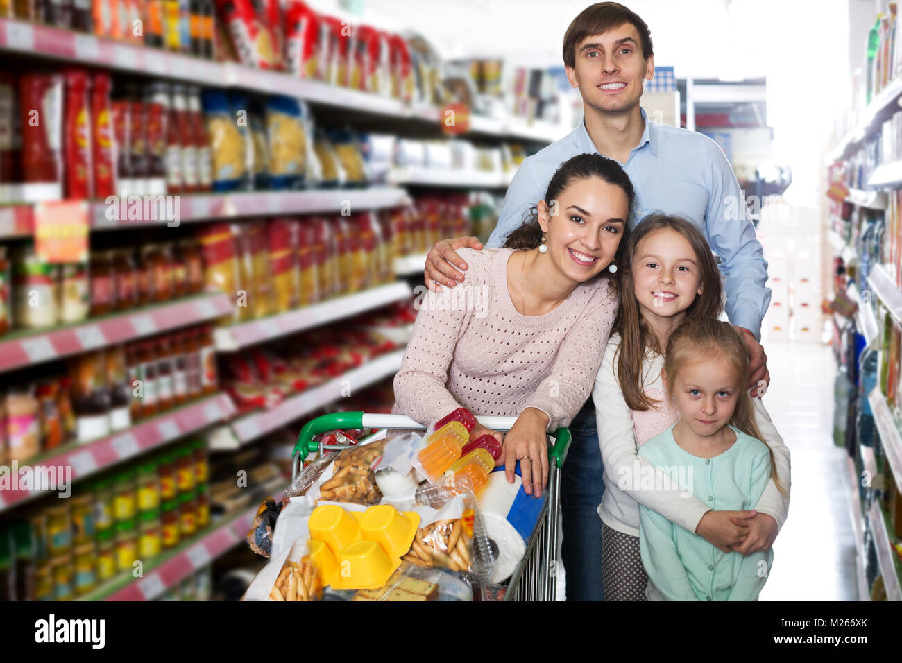 Smiling family with two daughters shopping in local supermarket Stock ...