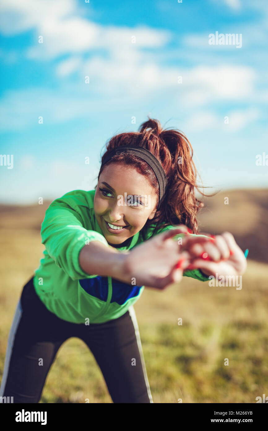 Young fitness woman doing stretching exercise after jogging in the ...