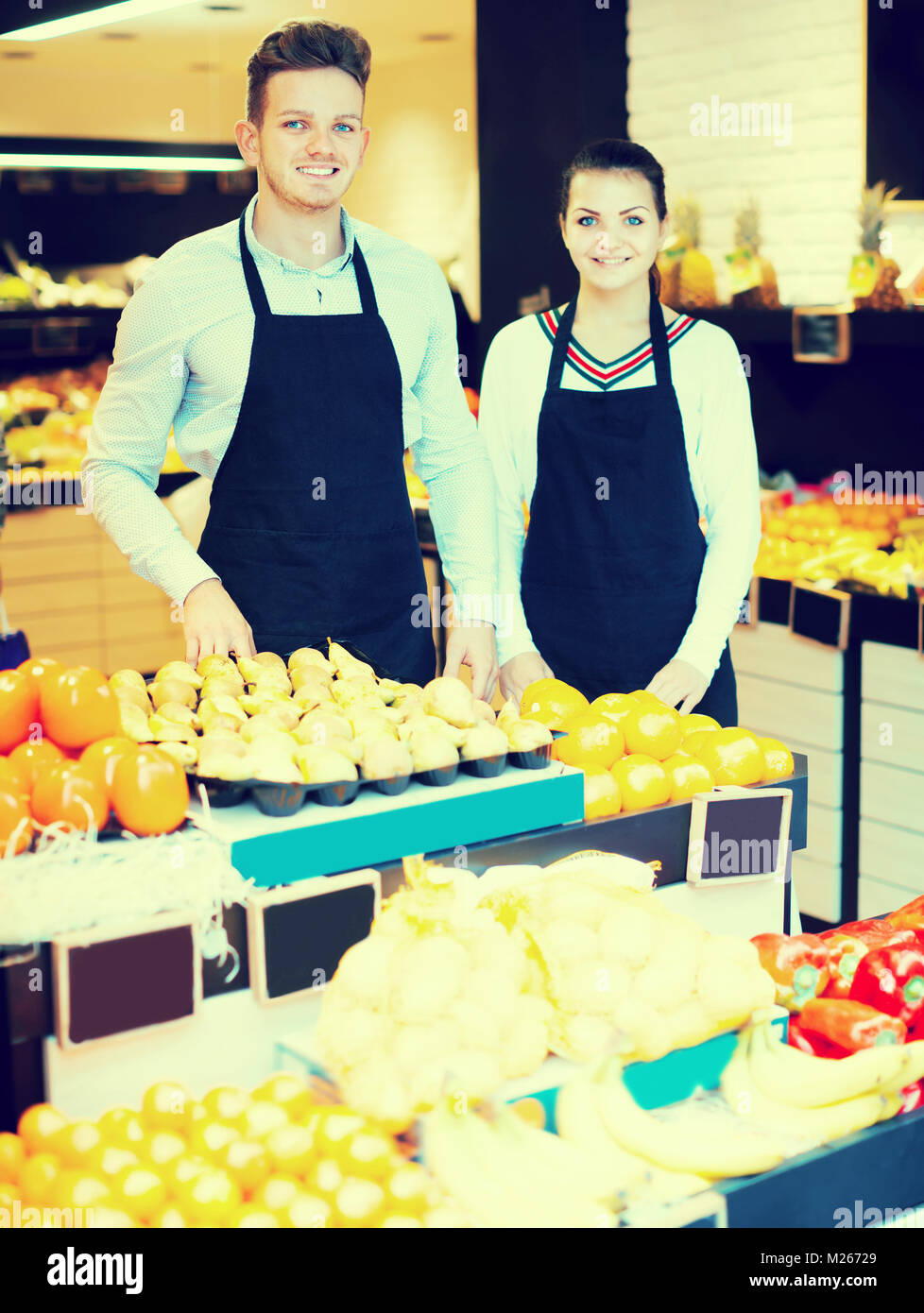 Happy shopping assistants demonstrating assortment of grocery shop ...