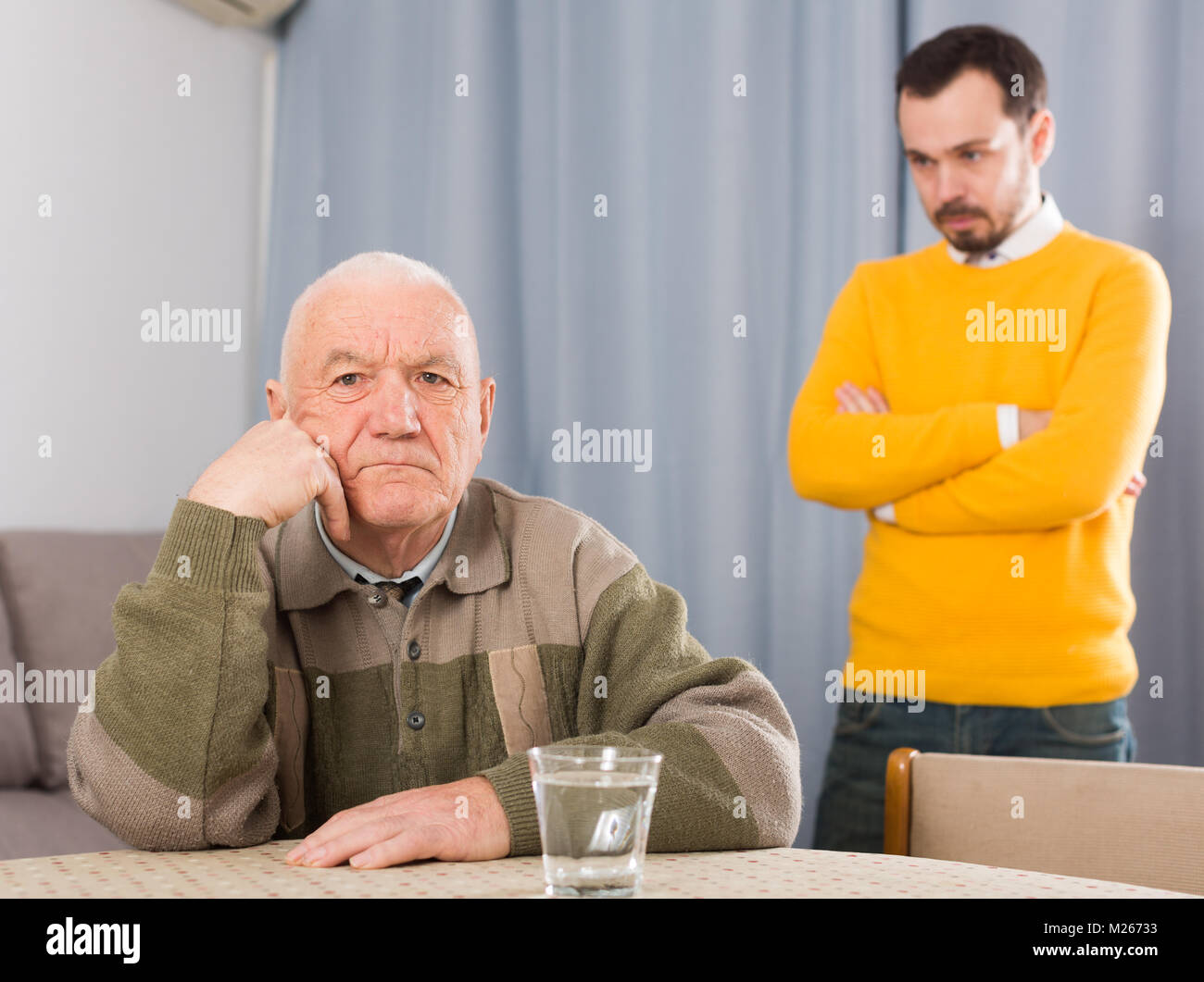 Old father is serious conversation with his son at home Stock Photo - Alamy