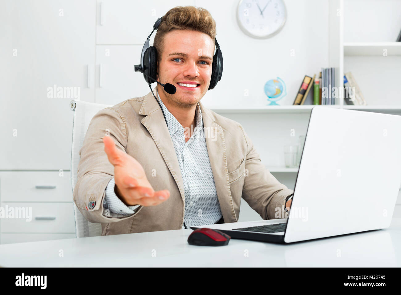 Friendly smiling call center male operator talking with client in ...