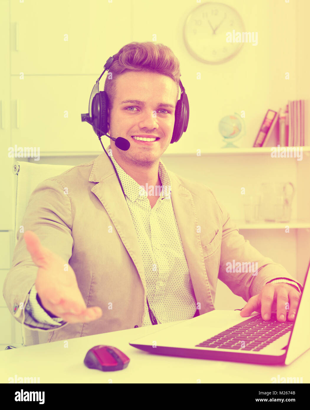 Smiling call center male operator talking with client in agency Stock Photo - Alamy