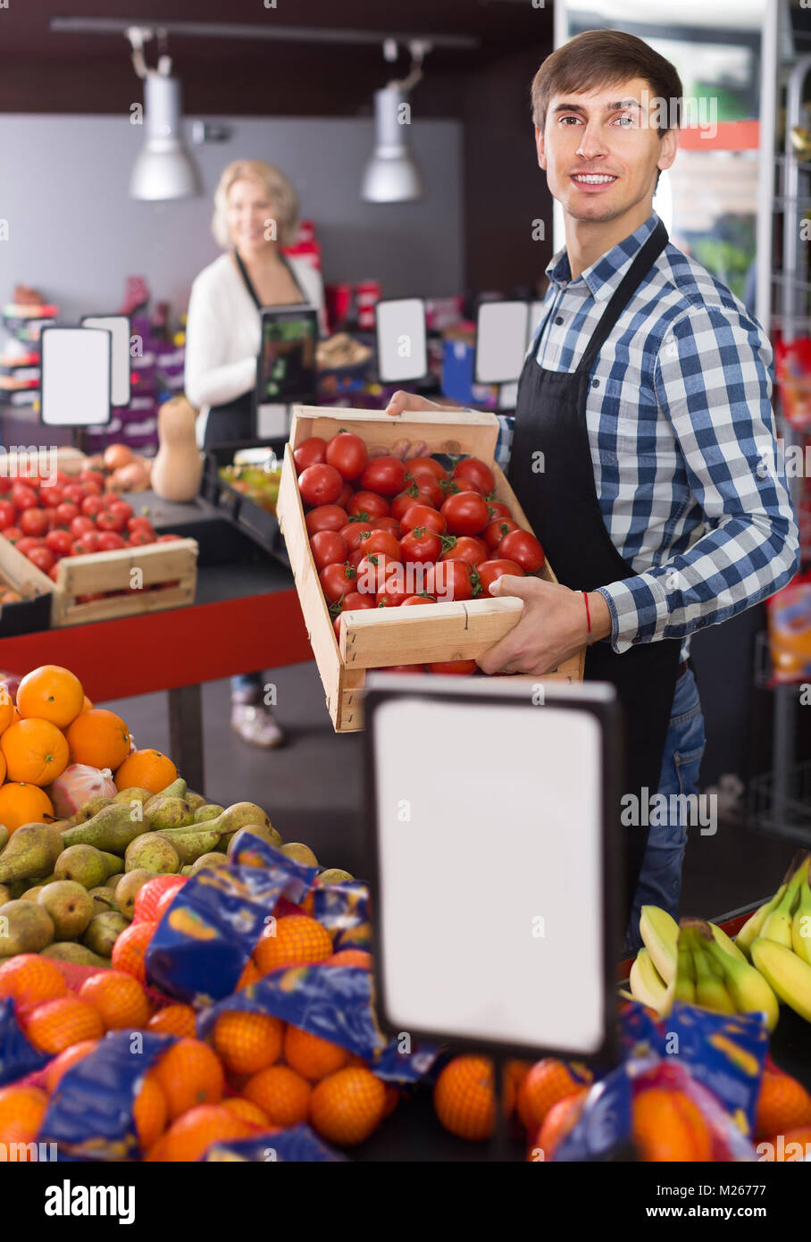 Young employee of farm food store with fruits and vegetables Stock ...