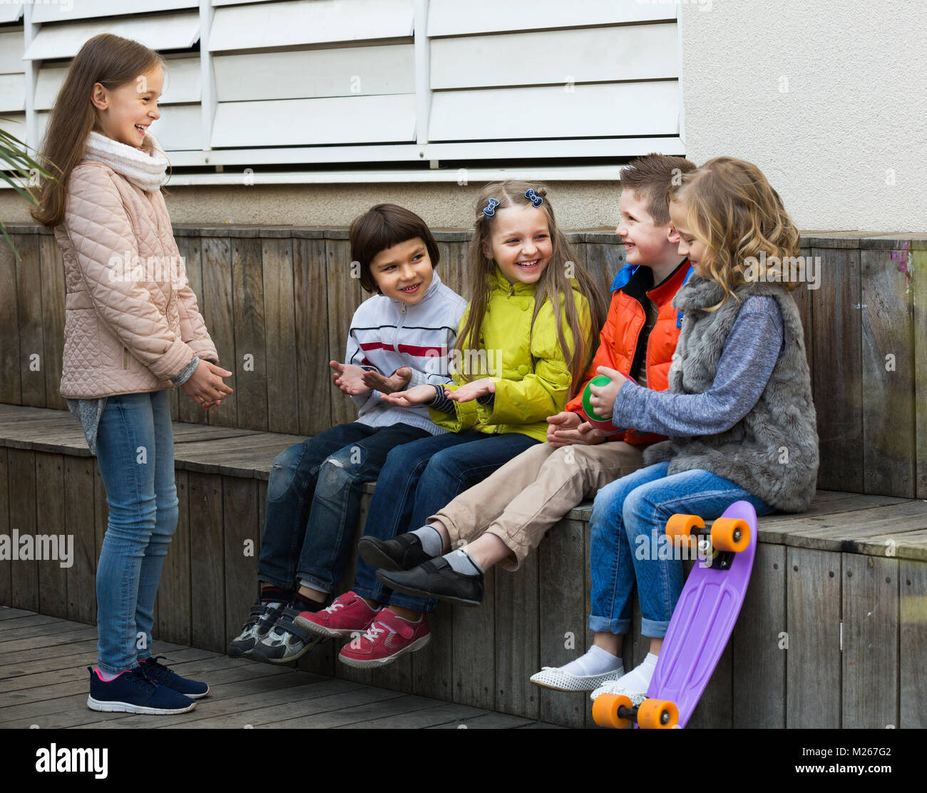 Smiling kids with small ball playing in city street Stock Photo - Alamy