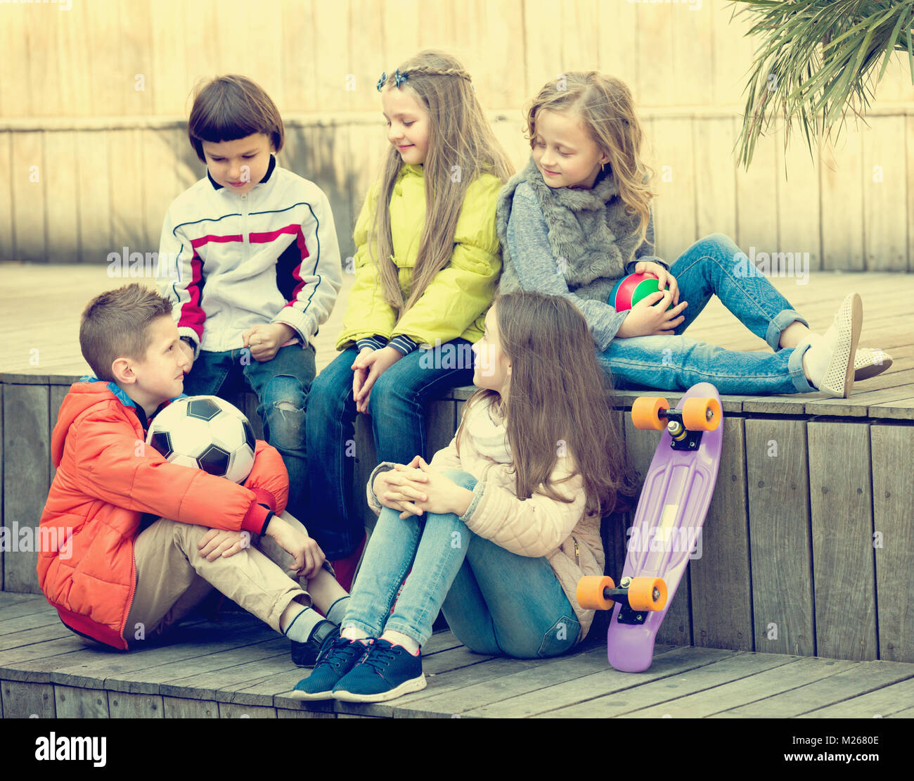Group of happy junior school children joyfully chatting and smiling ...