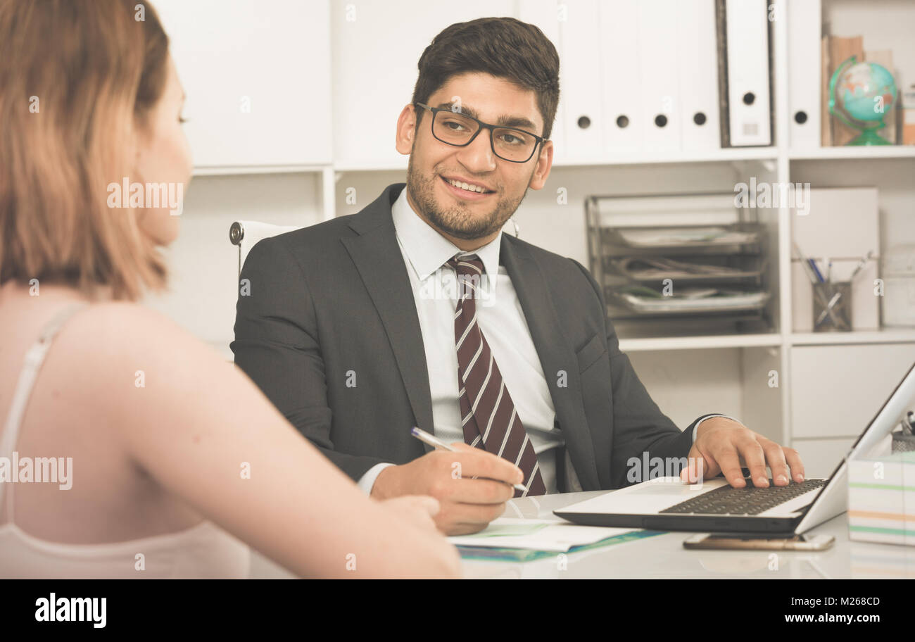 Positive businessman welcoming female client at workplace in office ...