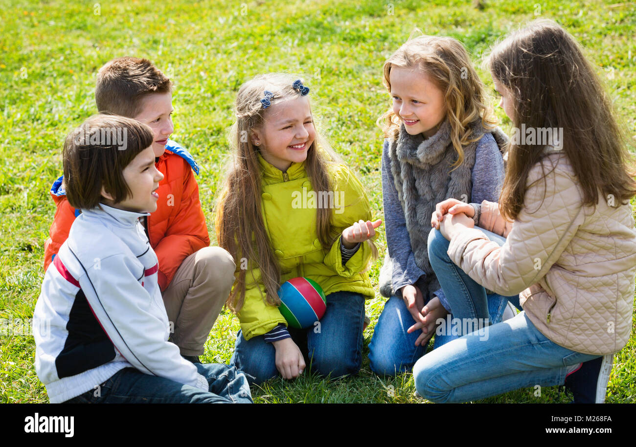 Group of happy children laughing and chatting in spring park Stock ...